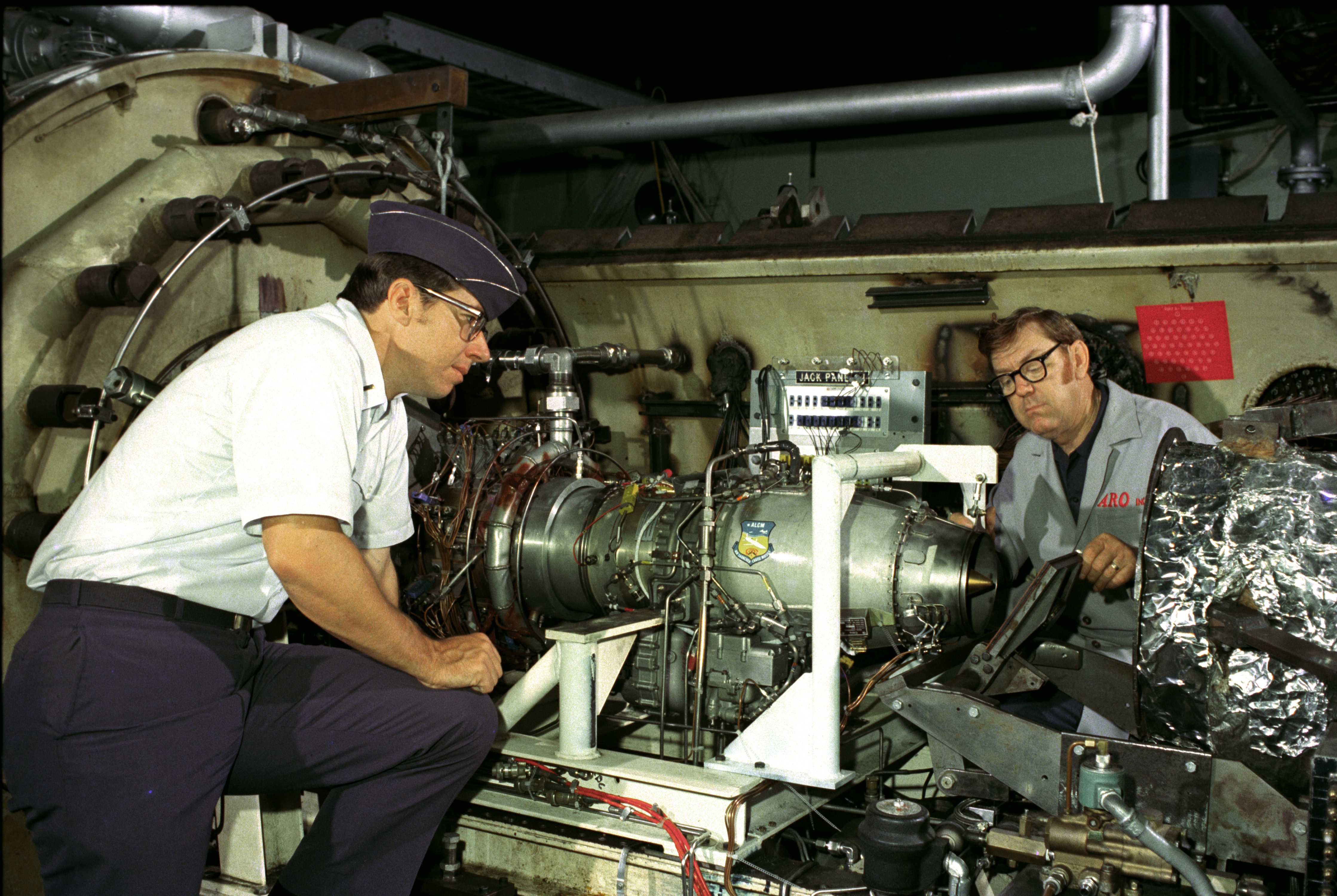 AEDC personnel check a quick-opening at the F107 turbofan engine's ...