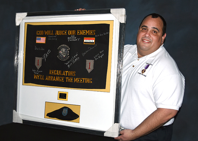 Rodriquez poses with framed guidon