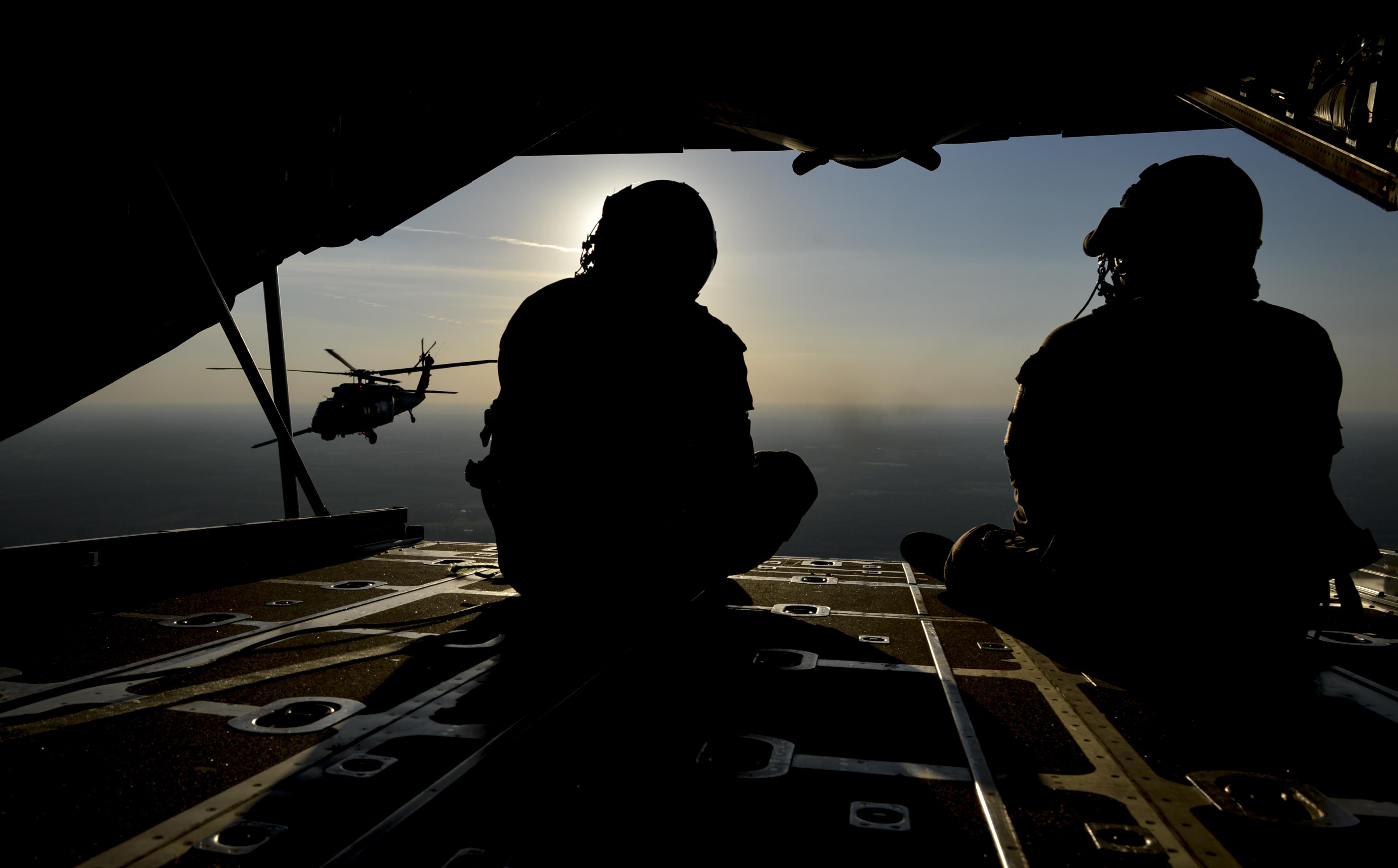 Loadmasters watch as a USAF HH-60 Pave Hawk is refueled from an HC-130 ...