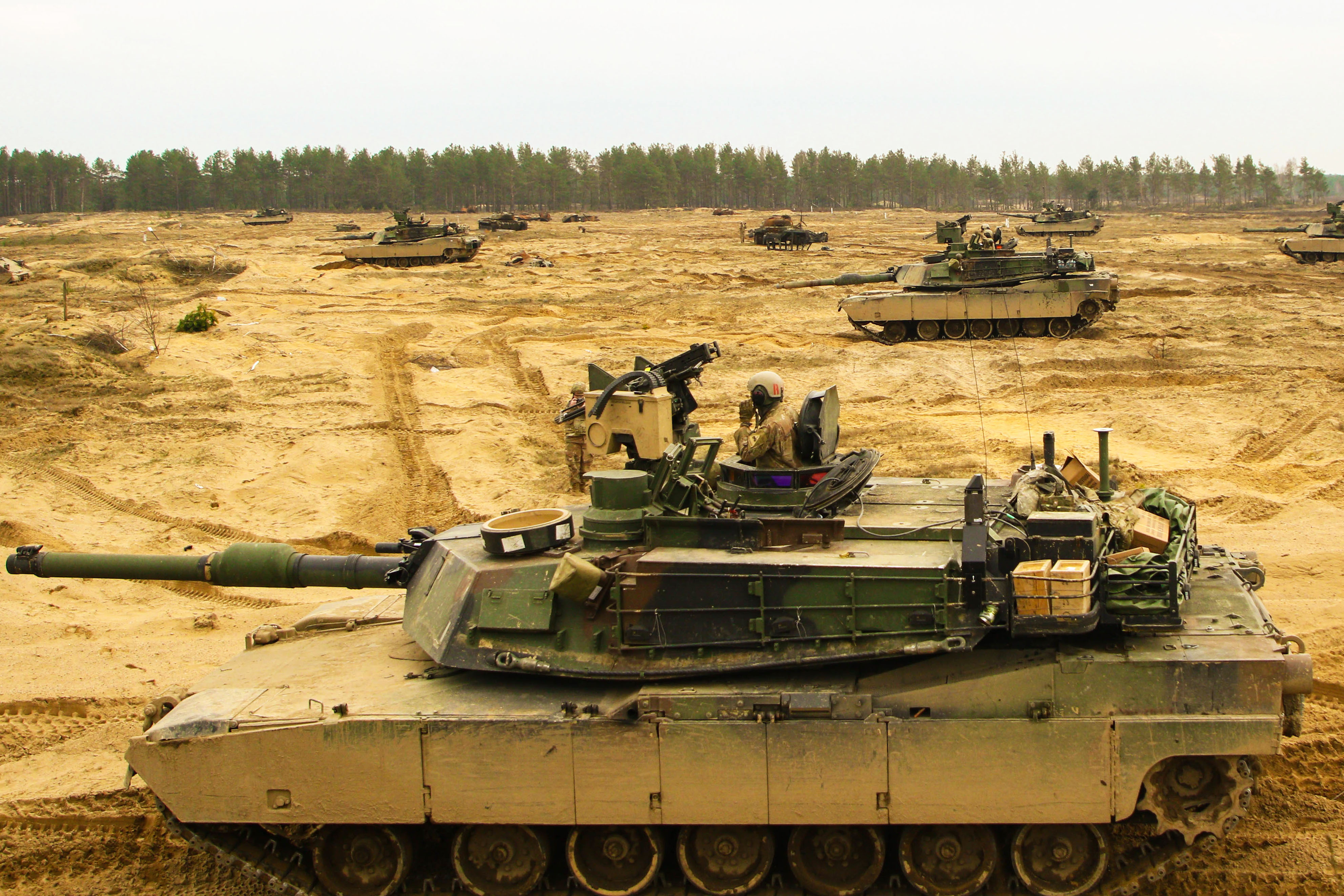 Soldiers set up a defensive position with M1 Abrams tanks during a live-fire exercise at Drawsko ...