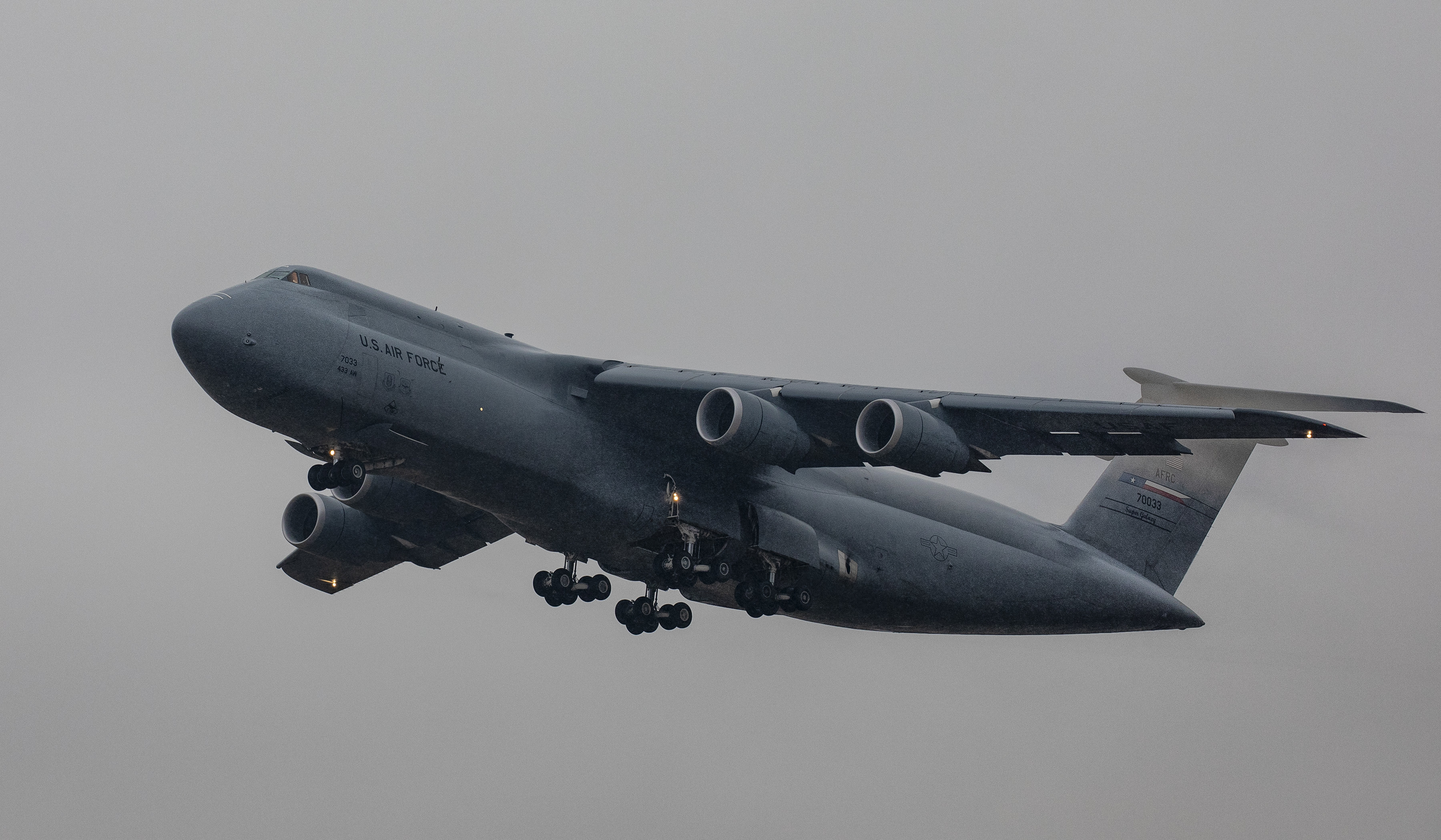 A C-5M takes off during snowstorm