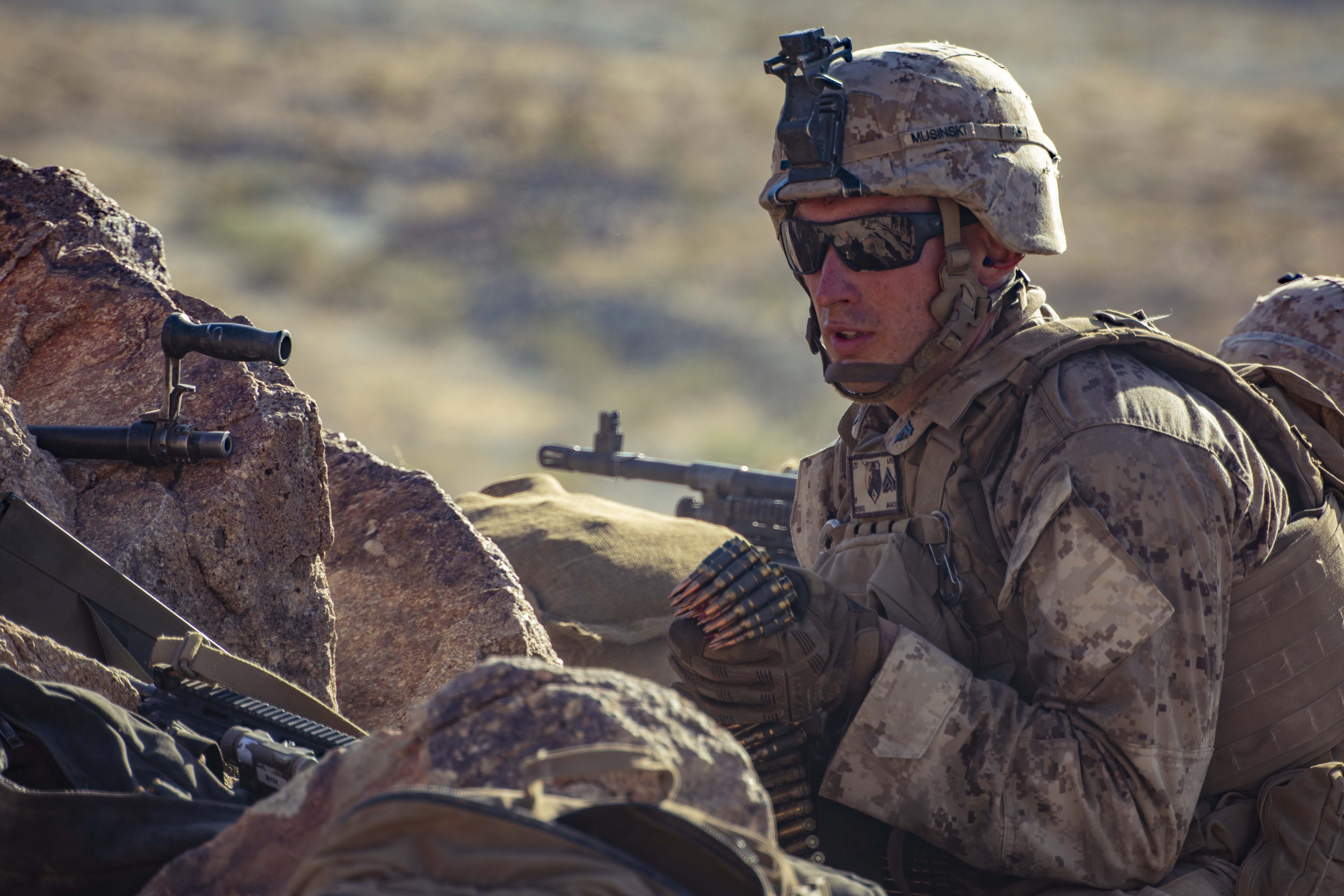 A Marine reloads an M240 machine gun during a simulated attack while ...