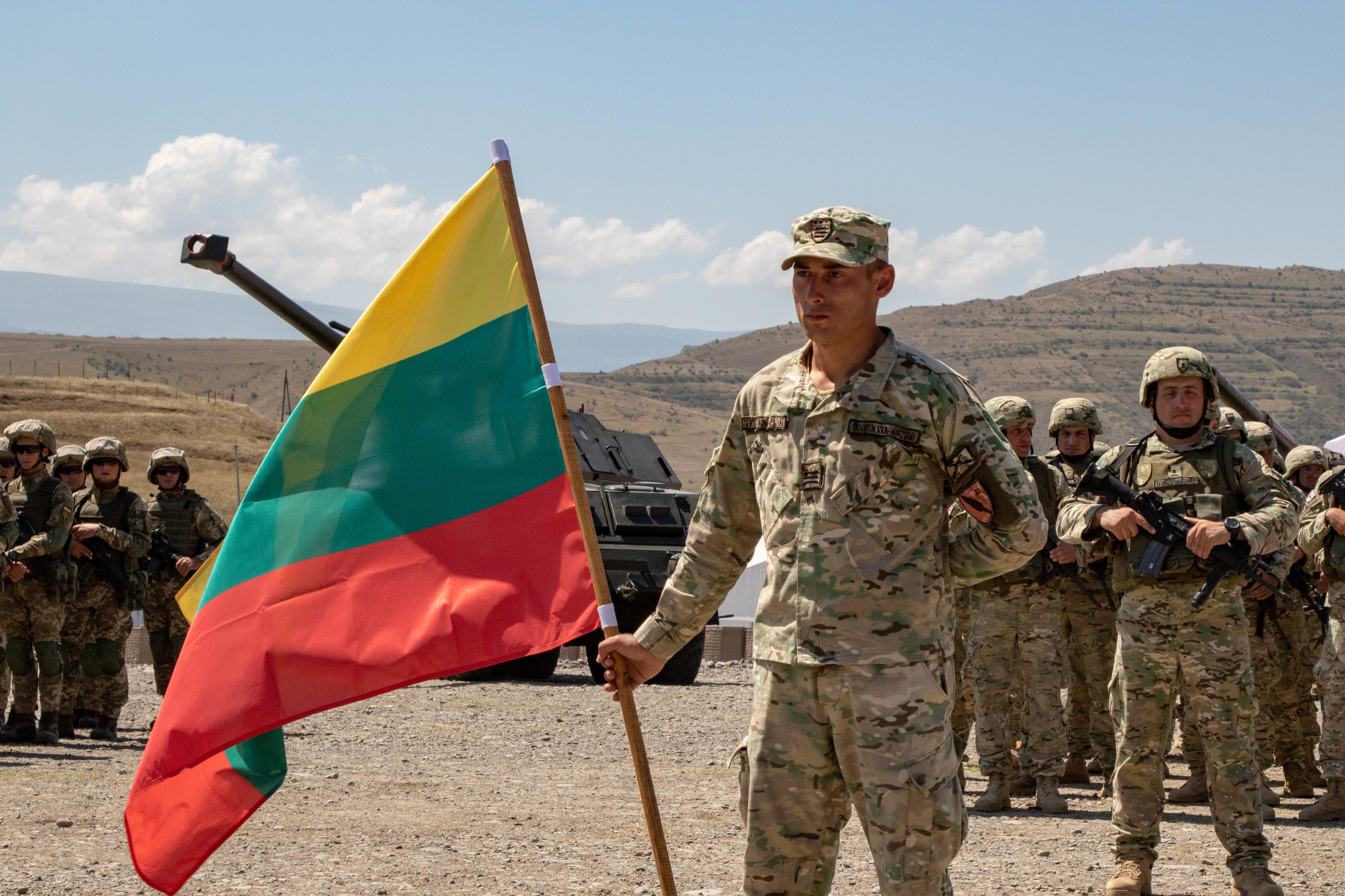 A Georgian Defense Force soldier holds the flag of Lithuania