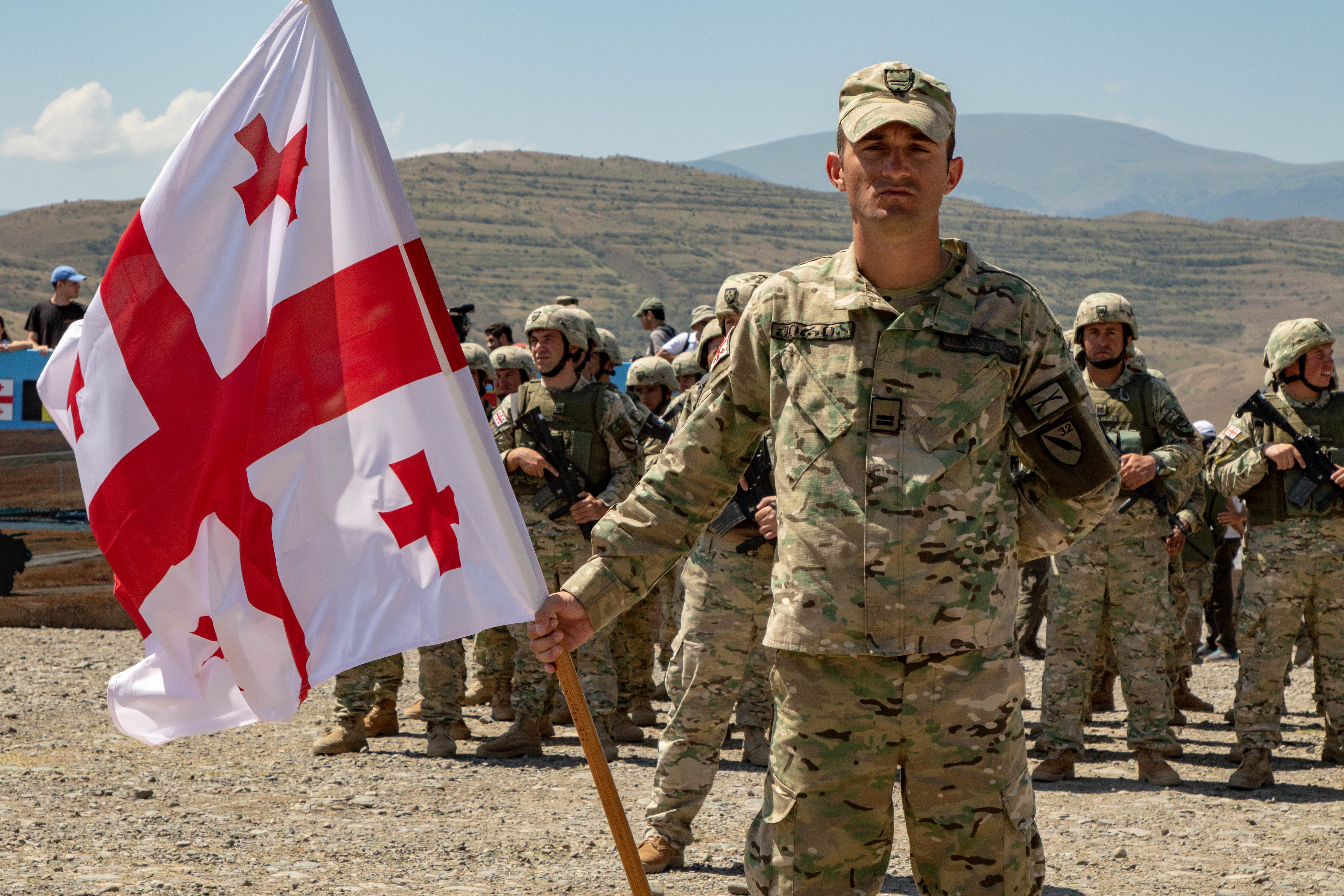 A Georgian Defense Force soldier holds the flag of Georgia