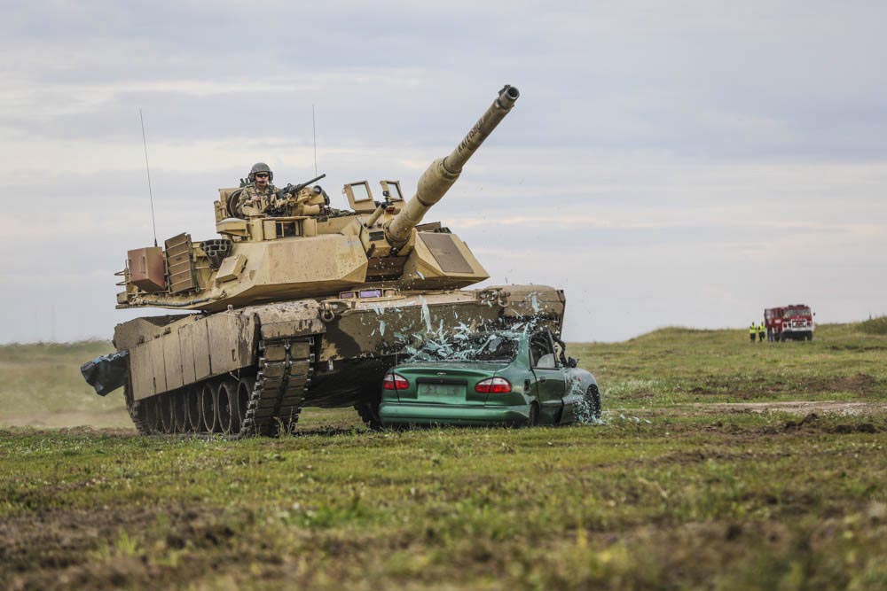 An M1 Abrams tank crushes a car during a simulated battle at Bemowo ...
