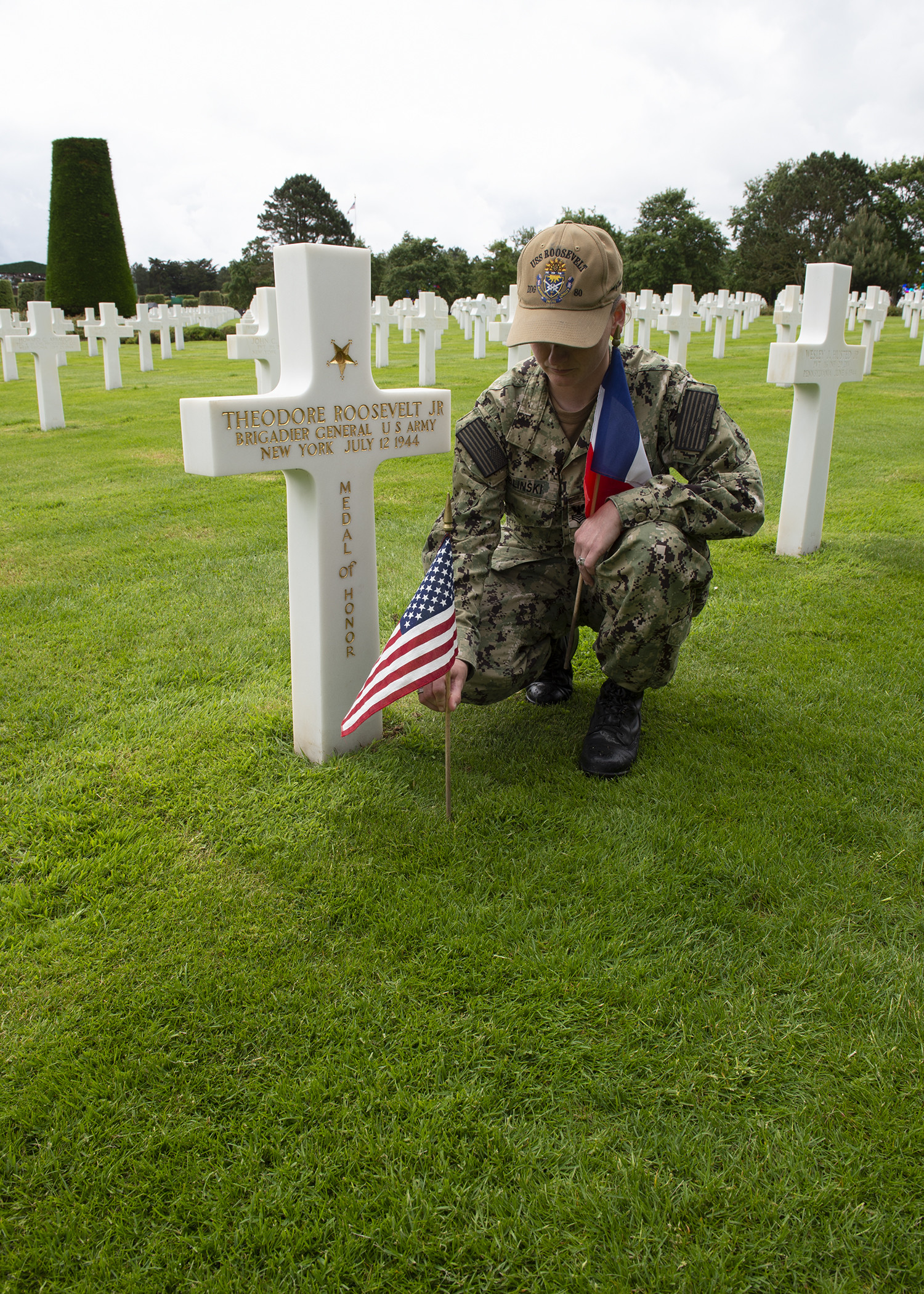 USS Roosevelt Sailor places flags at the Normandy American Cemetery ...