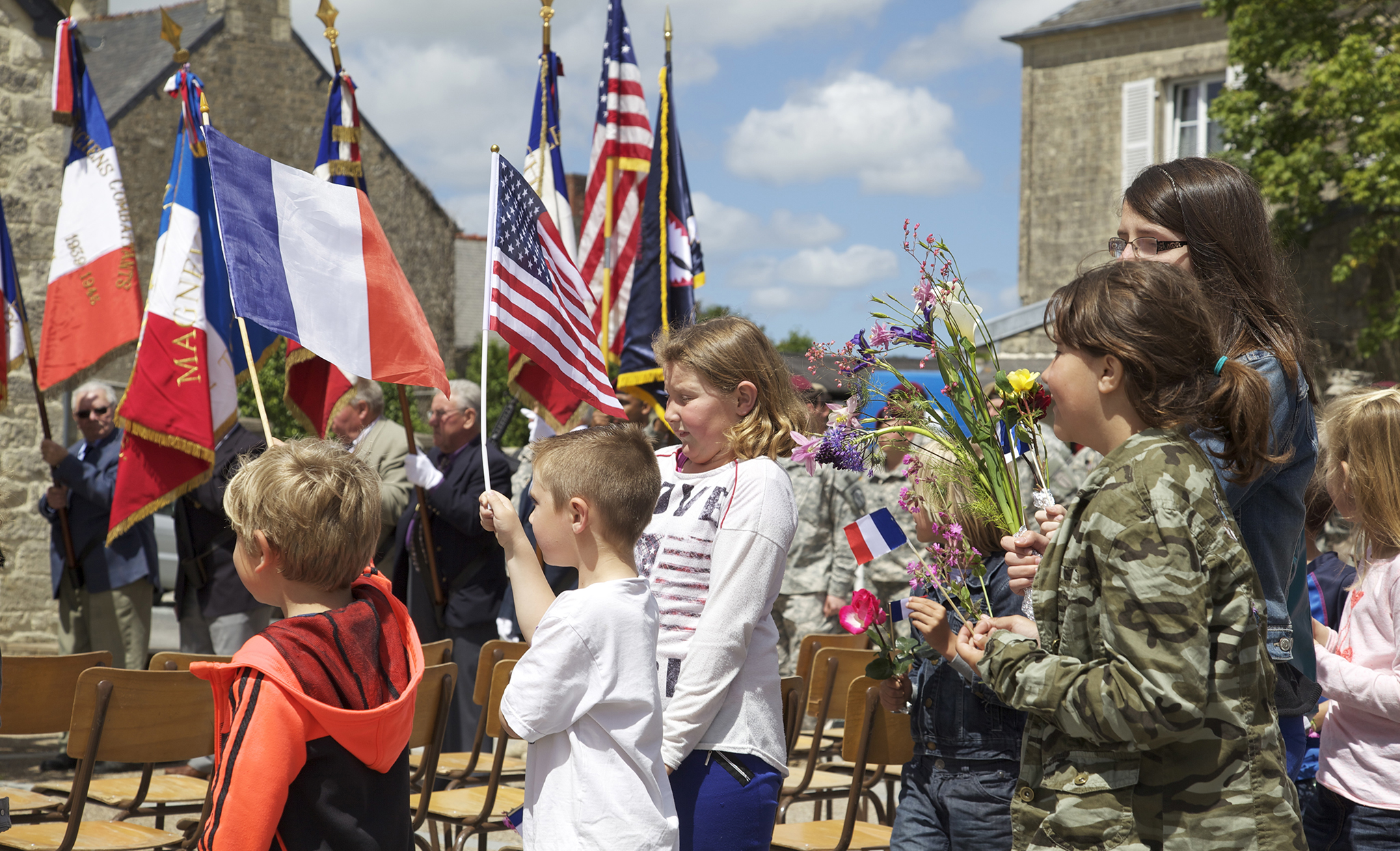 French school children wave American and French Flags during a ceremony ...