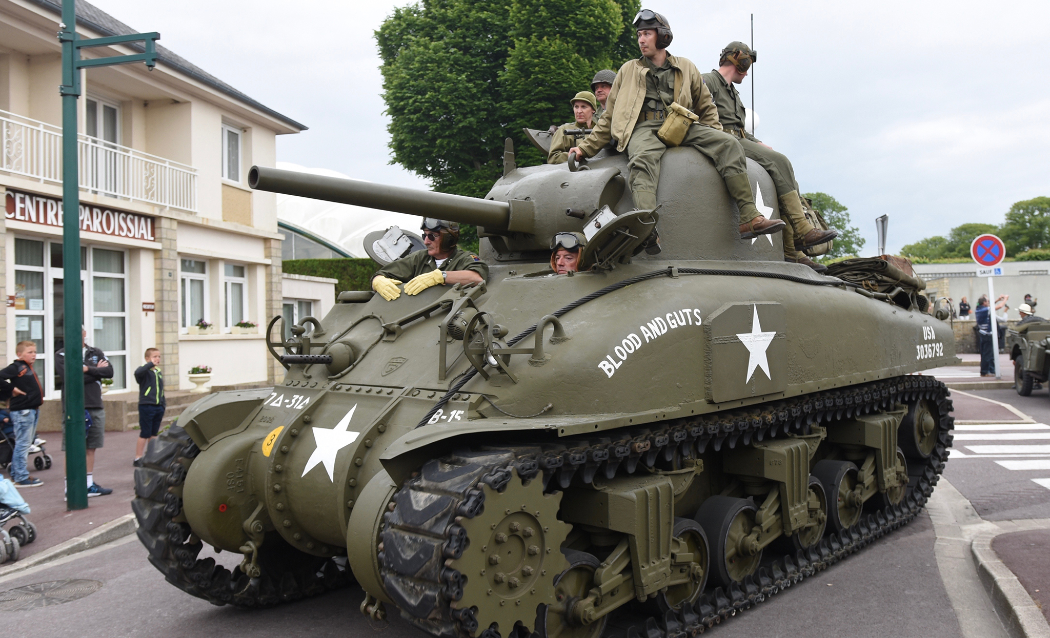 A replica of a U.S. Army tank rolls through the streets of Sainte Mere ...