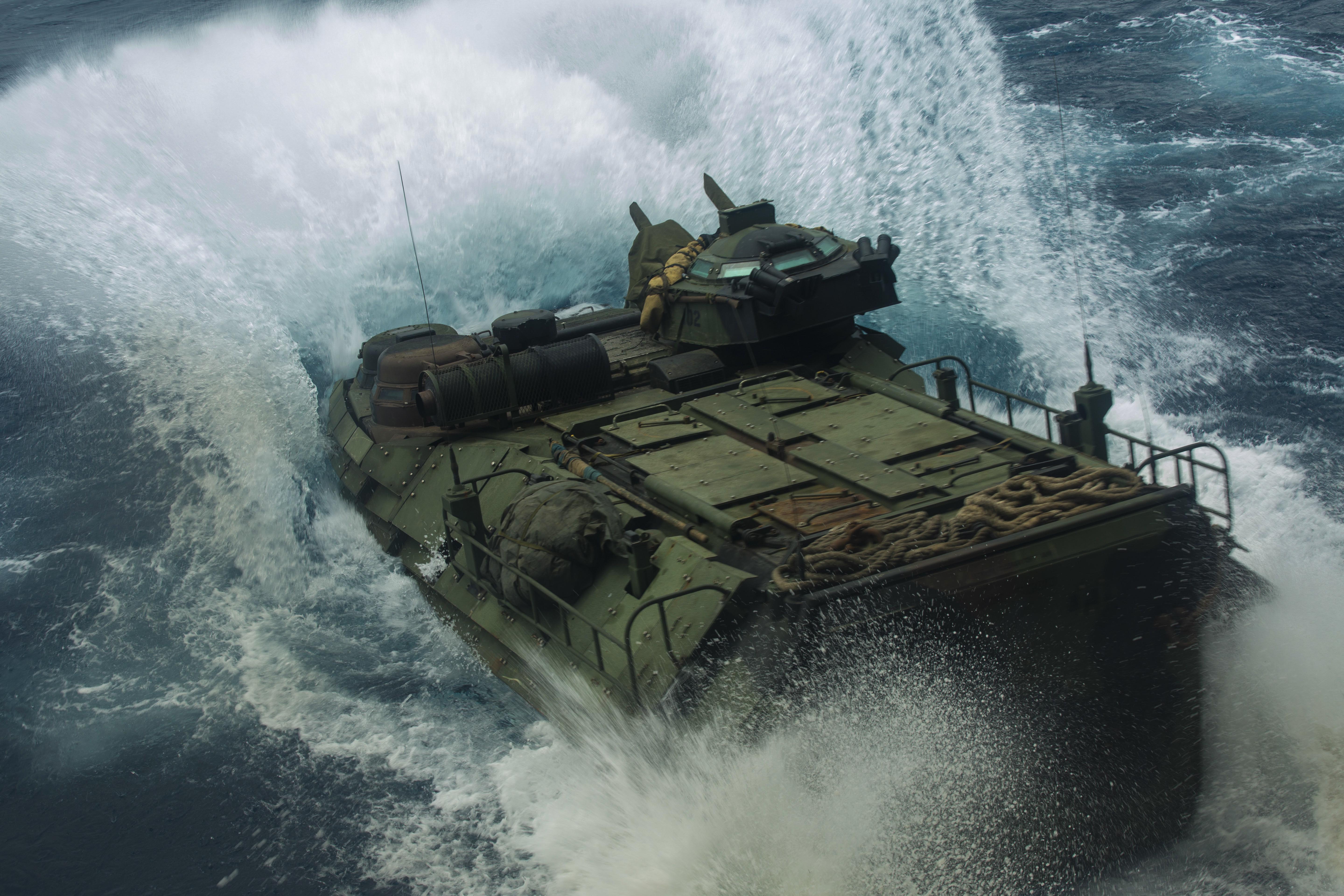 An amphibious assault vehicle splashes into water after exiting the ...