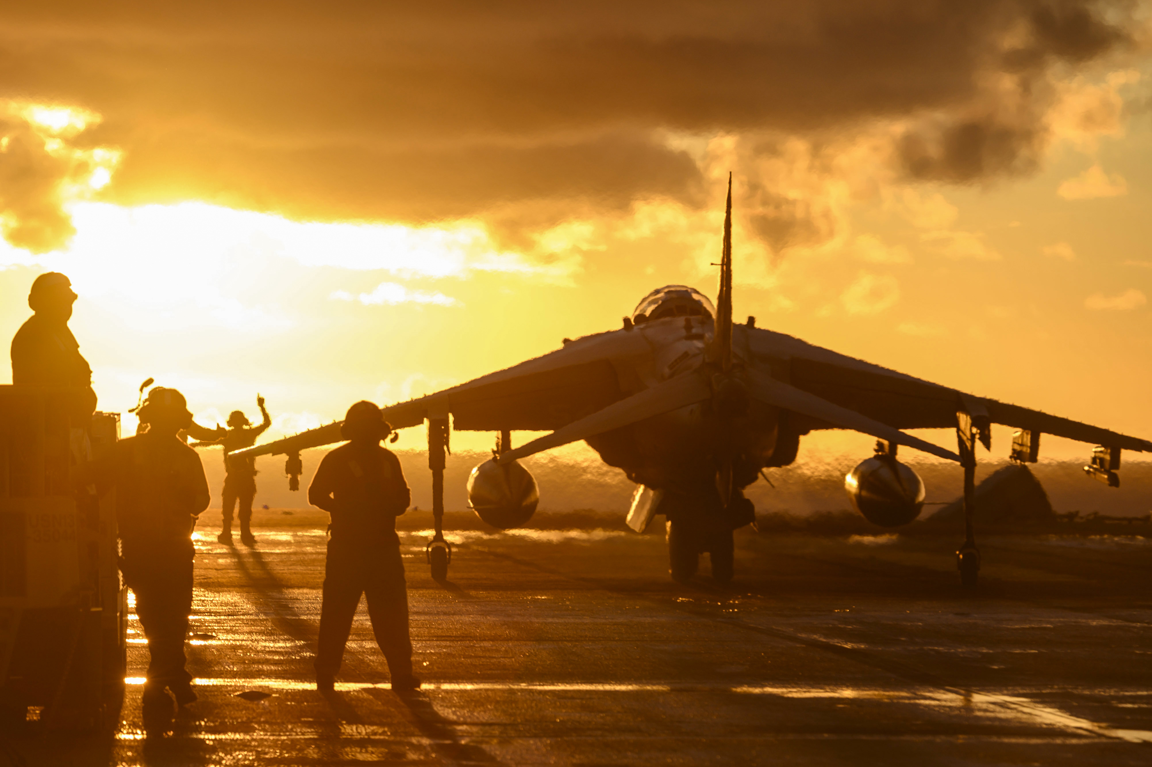 Sailors and Marines park an AV-8B Harrier II aircraft on the flight ...