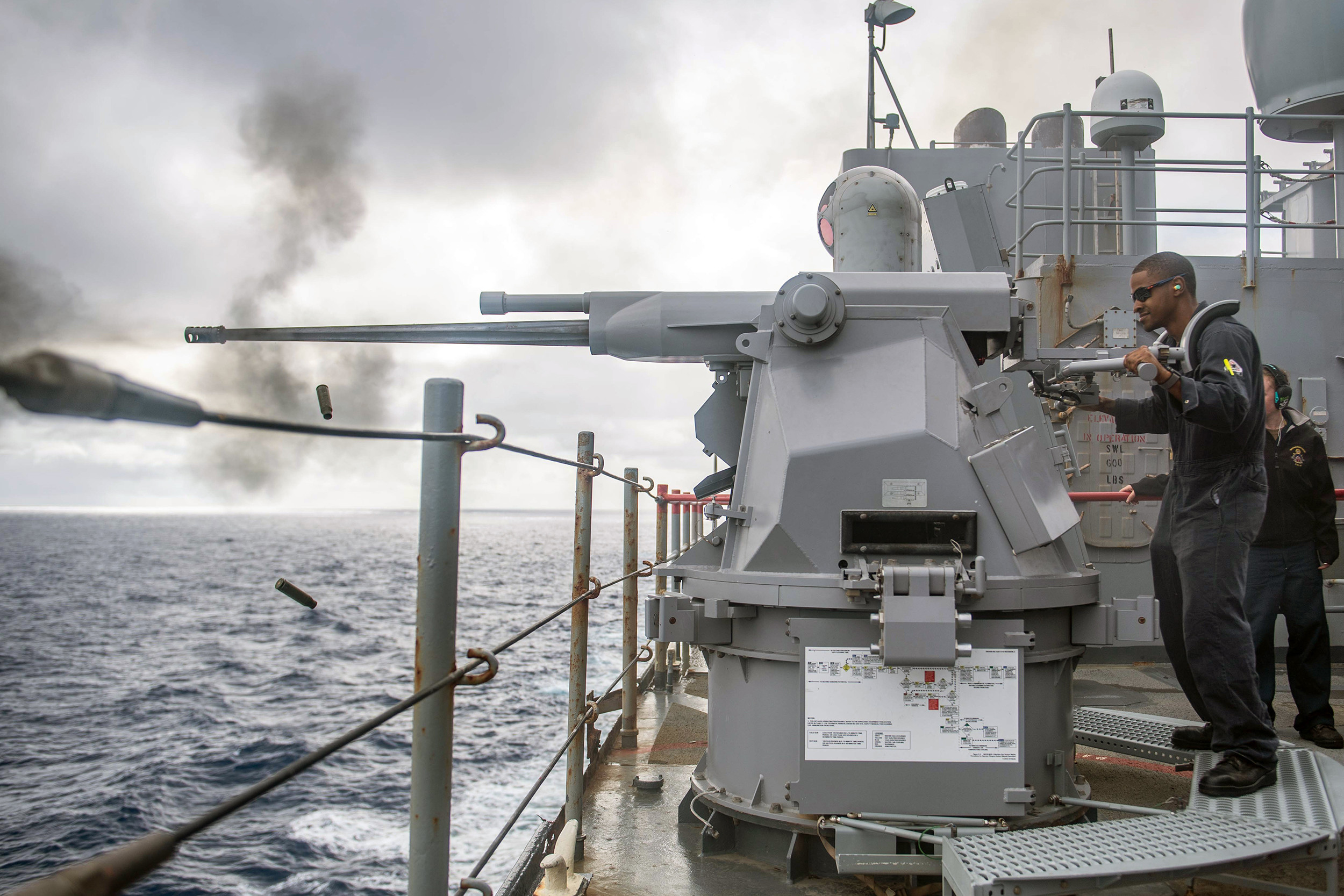 Navy Petty Officer 2nd Class Koree Johnson fires a machine gun during a ...