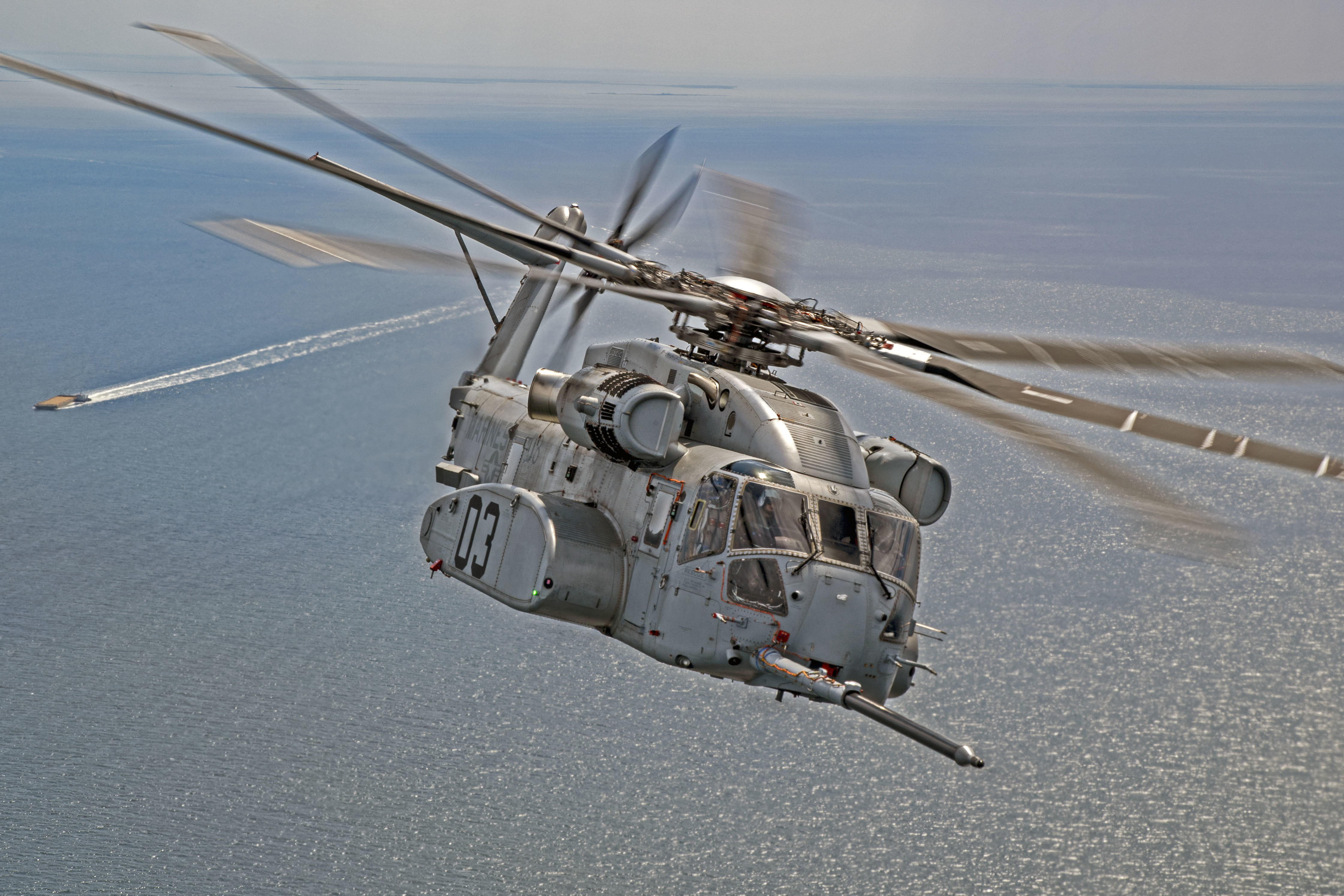 A CH-53K King Stallion helicopter prepares to plug into a funnel-shaped ...