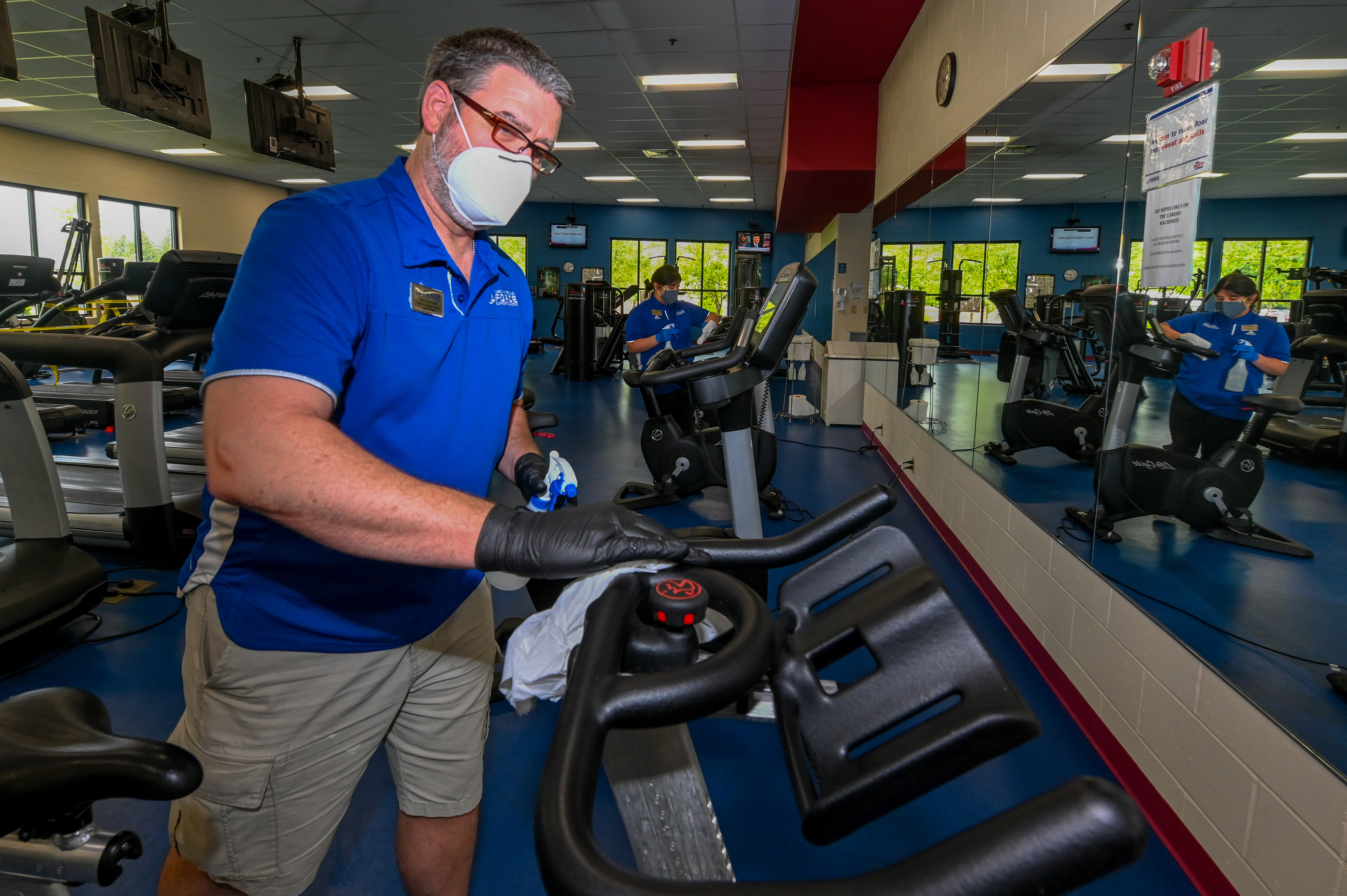 Fitness Center staff clean exercise equipment