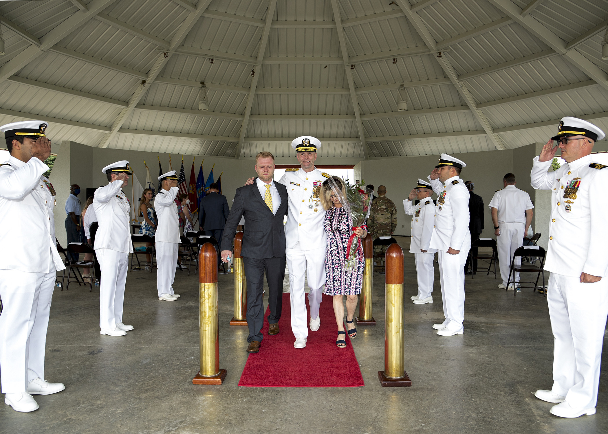 Navy Rear Adm. (ret.) John T. Palmer is escorted by his wife and son as ...