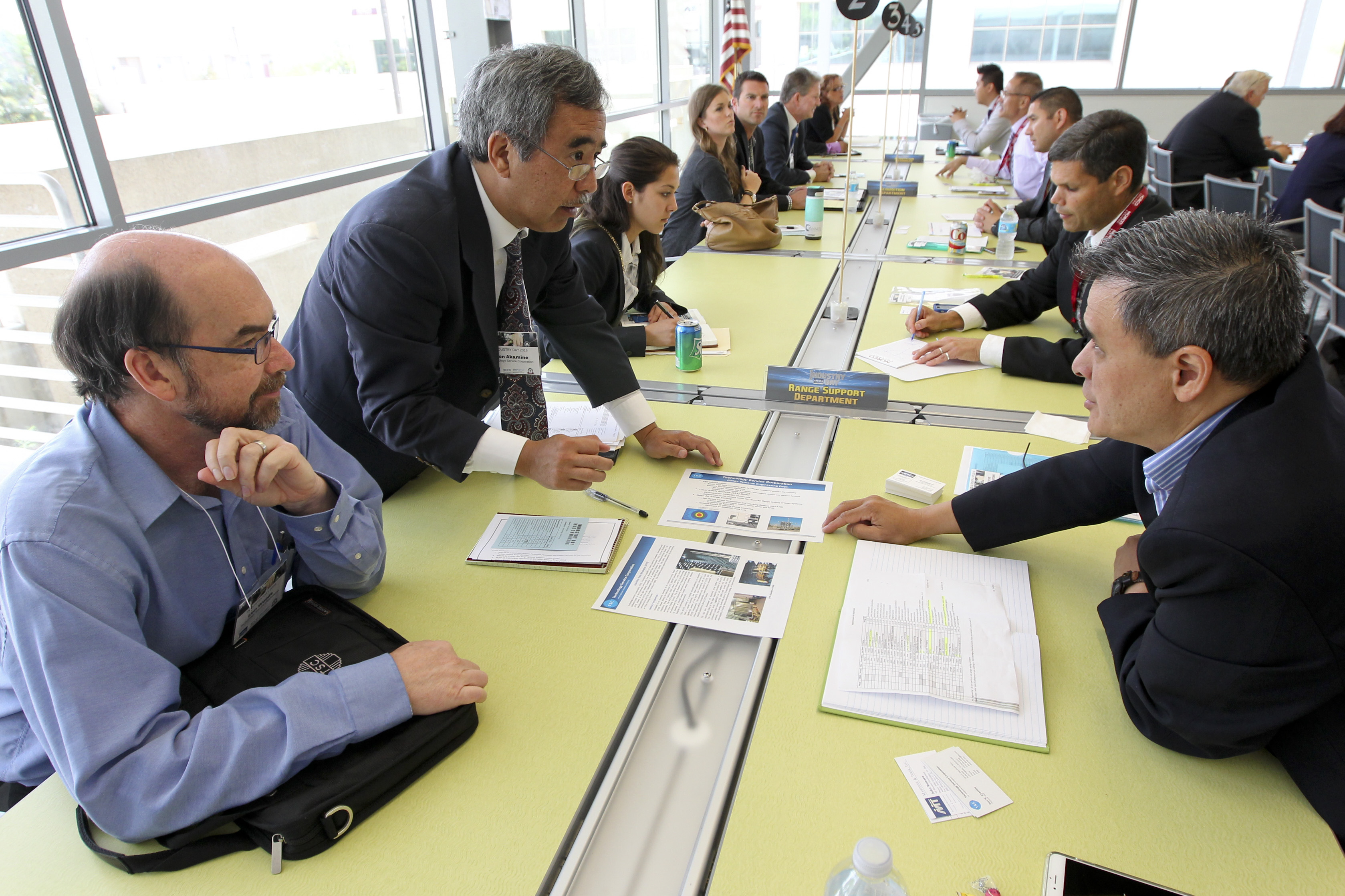 Don Woods, seated left, and Don Akamine, representing Technology Service Corporation, meet with ...