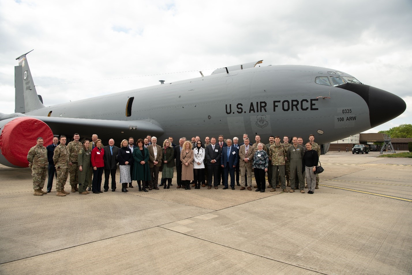 A group of new honorary commanders pose with military members in front ...