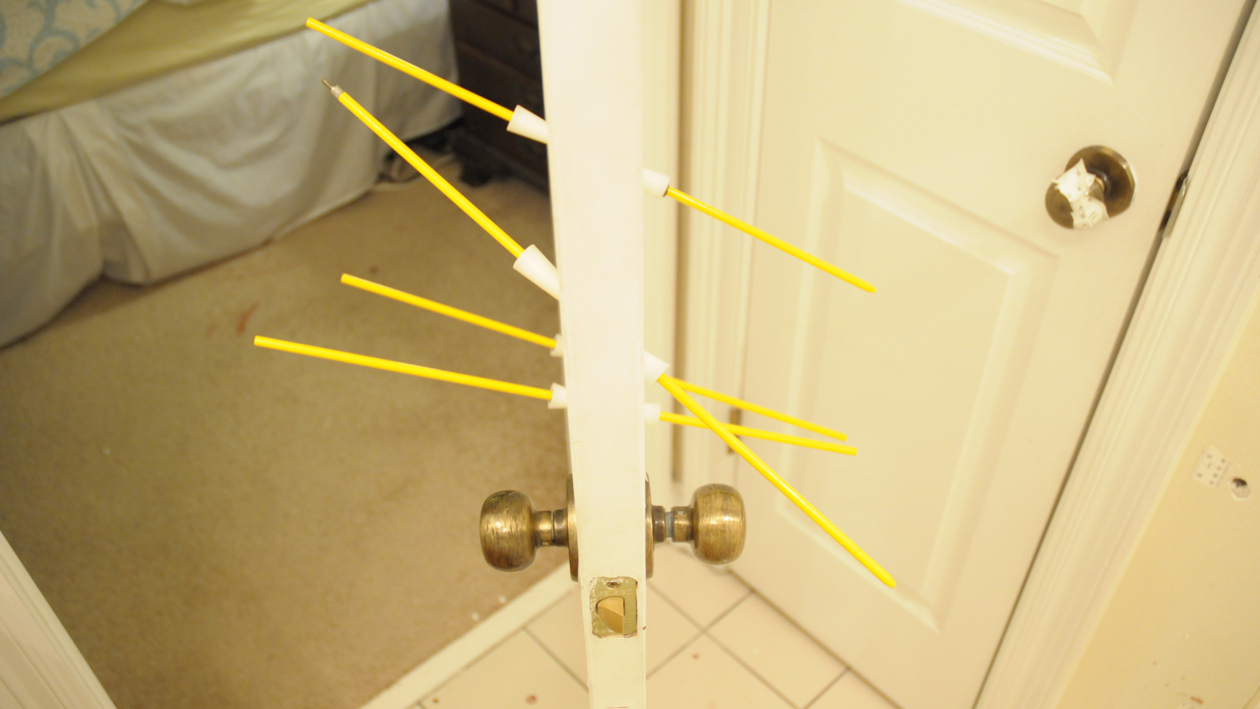 Bullet trajectory measuring rods through door at incident scene