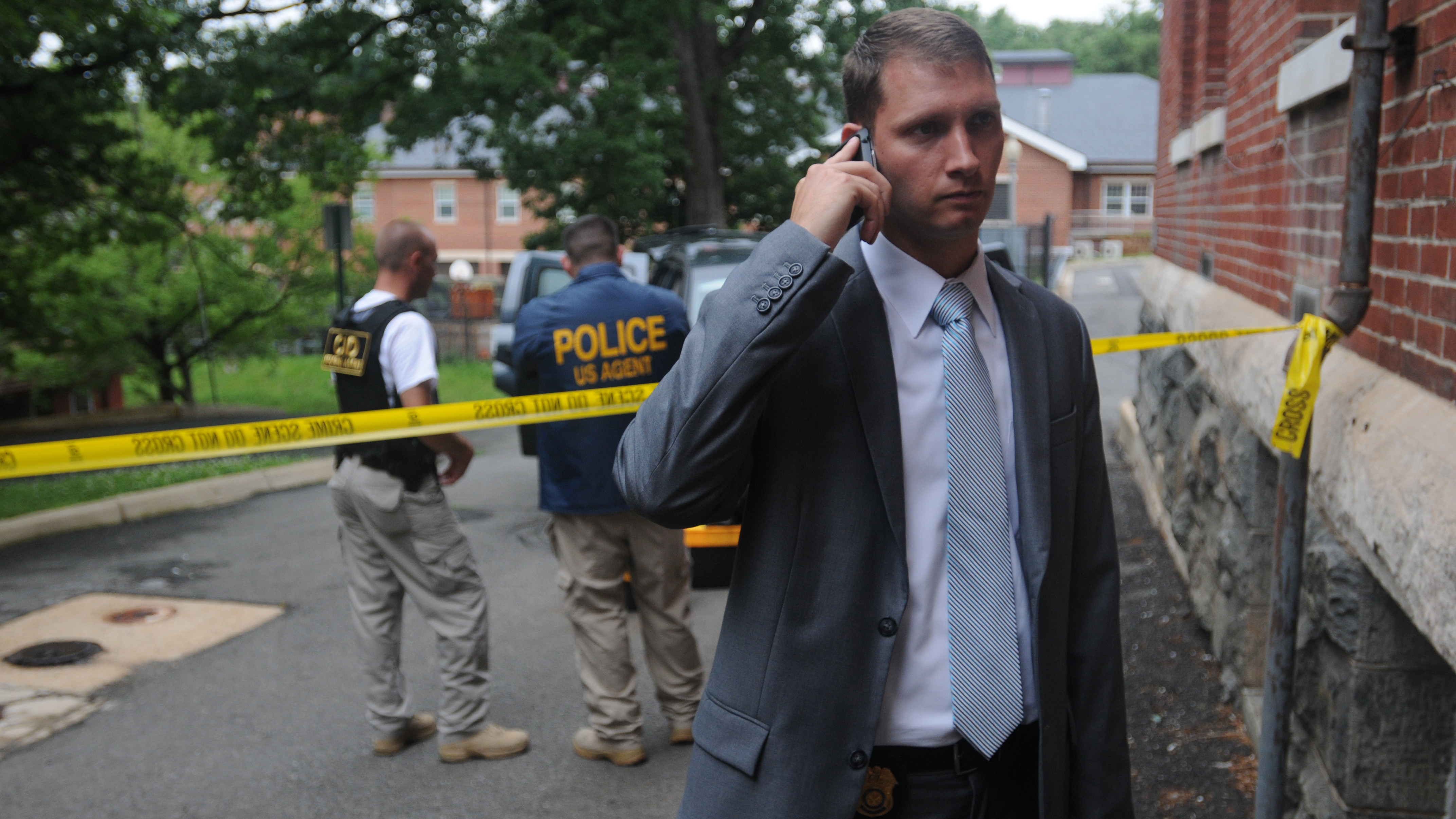 CID Agents talking on phone and conversing at incident site