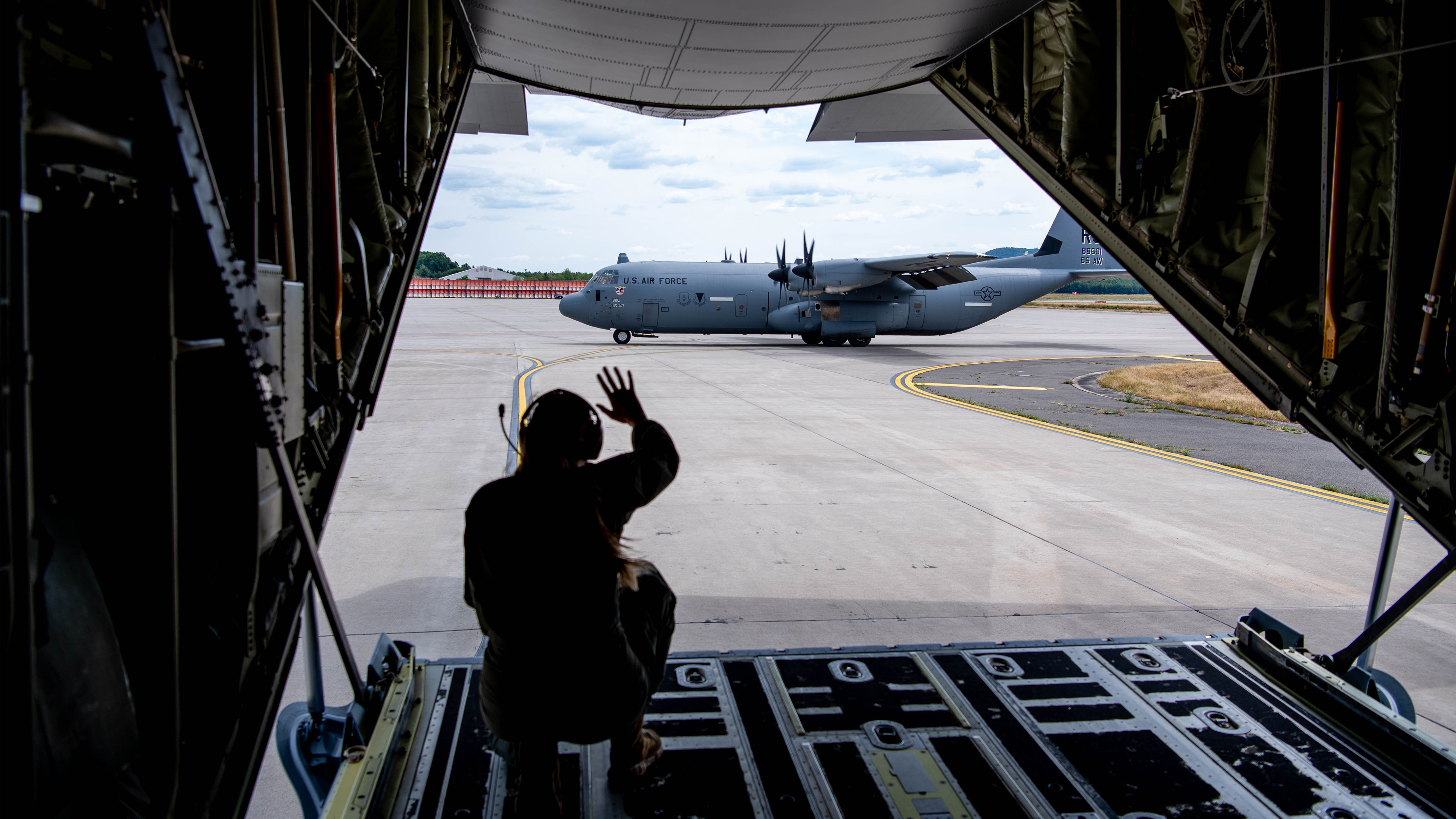 Loadmaster waves to aircraft