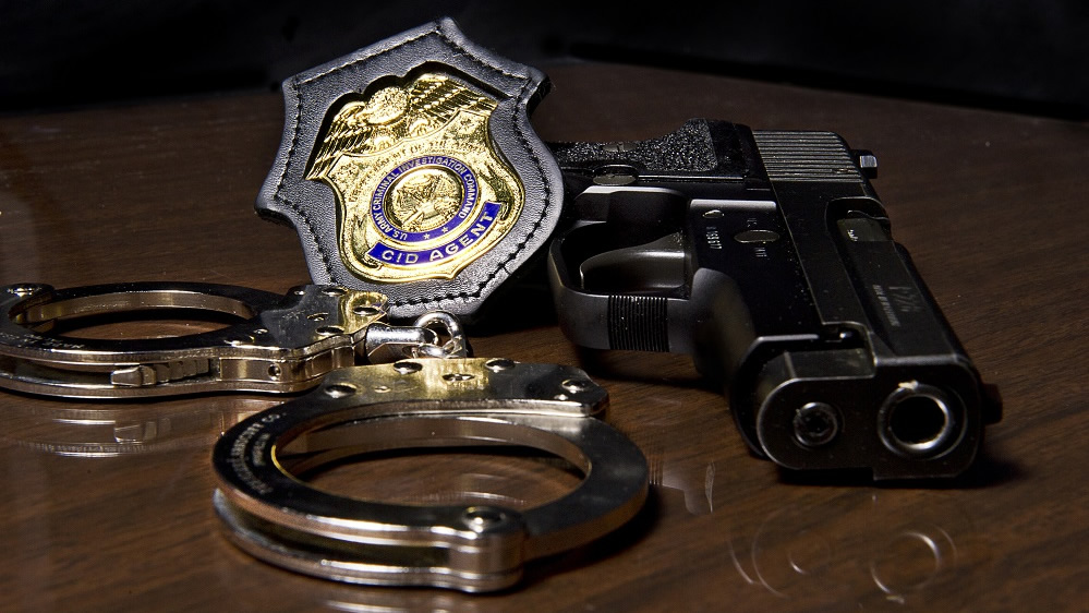 Special Agent badge, handcuffs and sidearm
