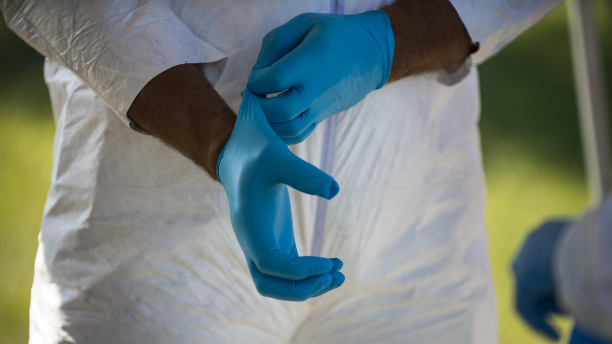 Army CID agent in putting on protective equipment before collecting ...