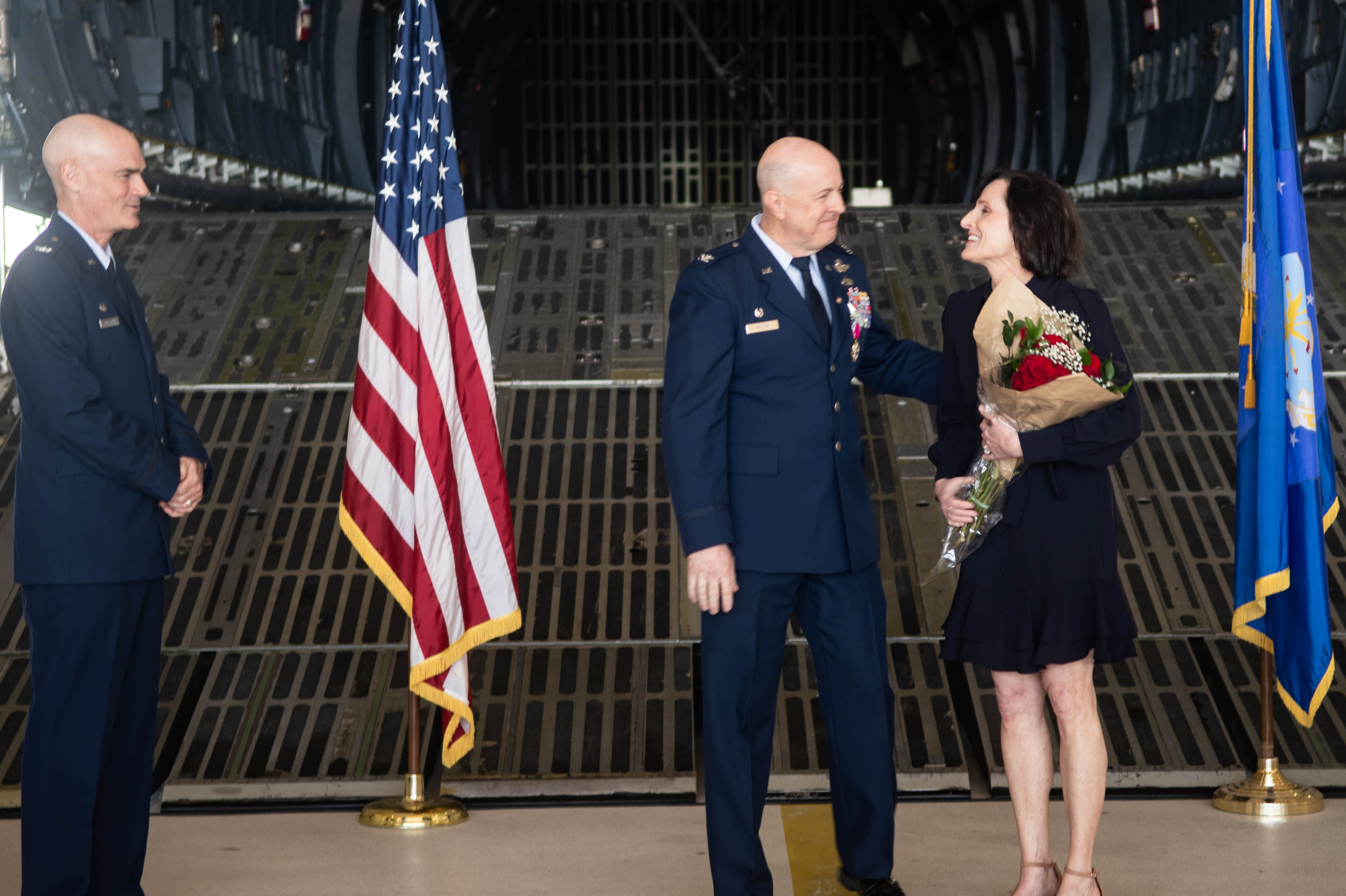 Col. James C. Miller, 433rd OG commander, presents flowers to spouse