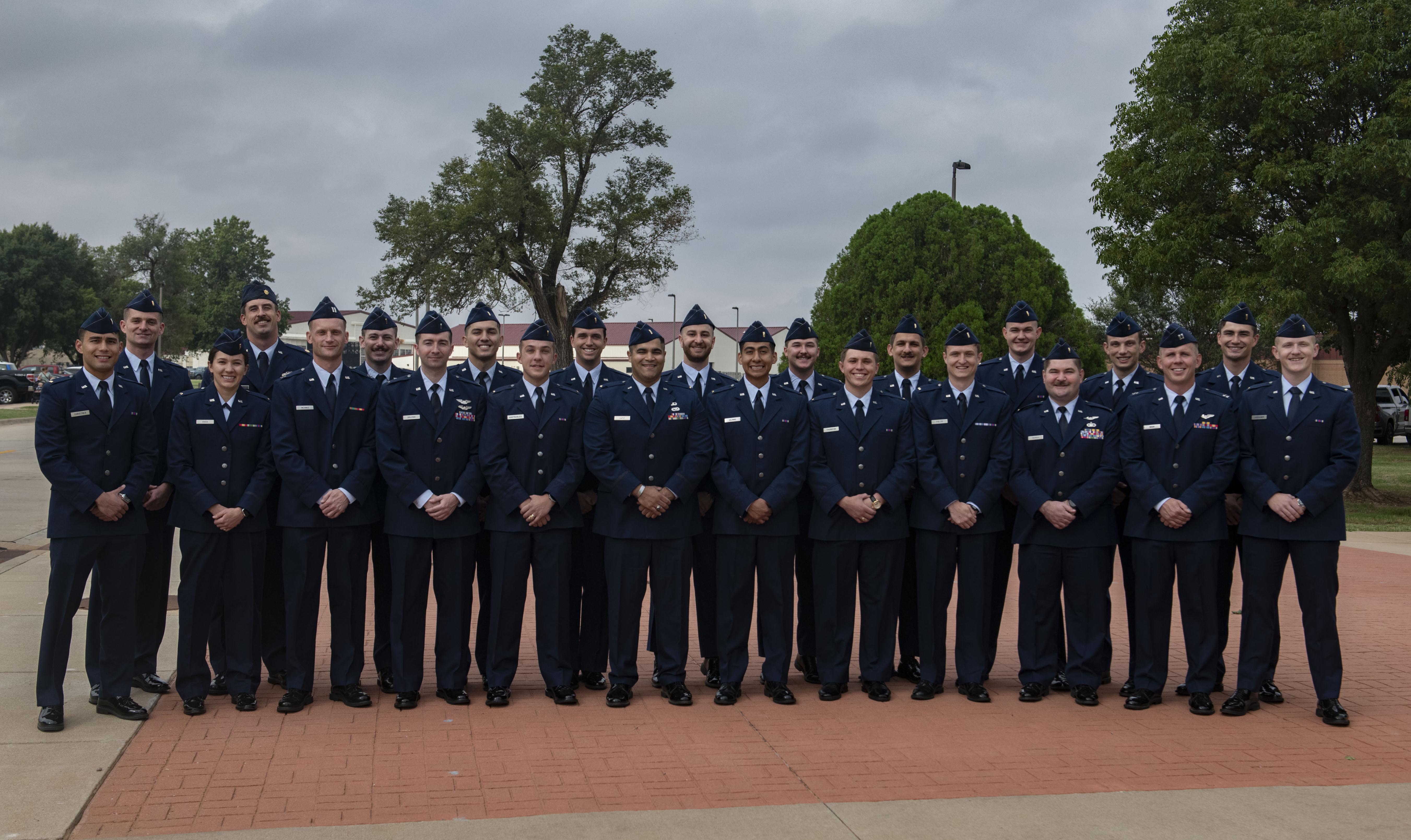 Student pilots in Class 25-13 pin on their wings during graduation Aug ...